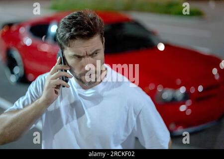 Gangster call phone. Angry man chatting on phone near car on night ...