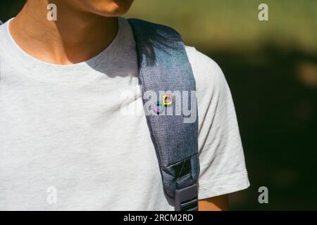 Adolescent boy with backpack with autism infinity rainbow symbol sign ...