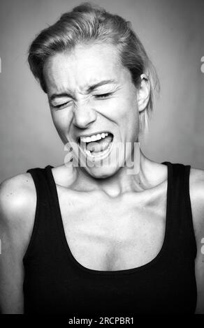 Screaming expression on the young woman's face Stock Photo - Alamy