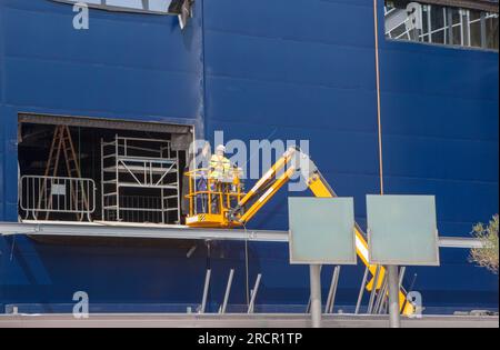 Worker installing insulating panels in a building under construction ...