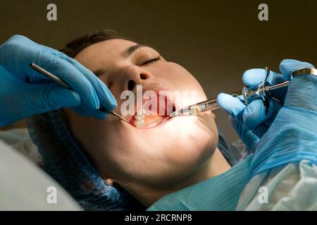 Dental surgeon performs conduction anesthesia with lidocaine using a ...