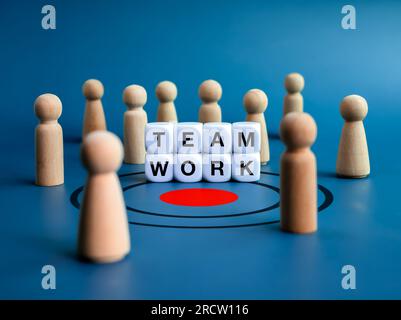 Wooden figures standing on puzzle pieces arranged in a circle ...