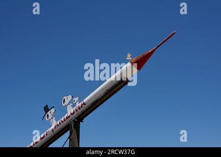 A roadway sign for the town of Wikieup, Arizona of a rocket with Snoopy ...
