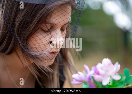Close up of grieving woman wearing black at outdoor funeral ceremony ...