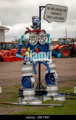 folk art statues made out of car parts in front of a tire & auto parts ...