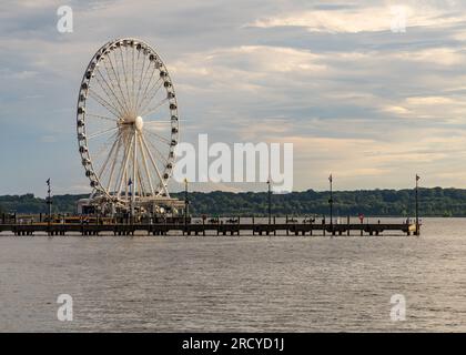 Wooden pier with the Ferris Wheel behind with skyline of National ...