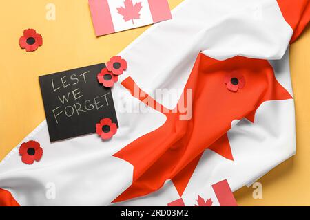 Poppy flowers with flags of Canada and card on grunge pink background ...