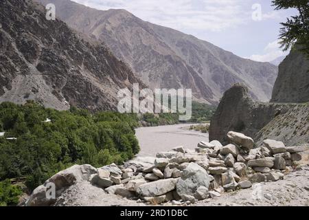 A stream coursing through the barren mountains and a patch of green ...