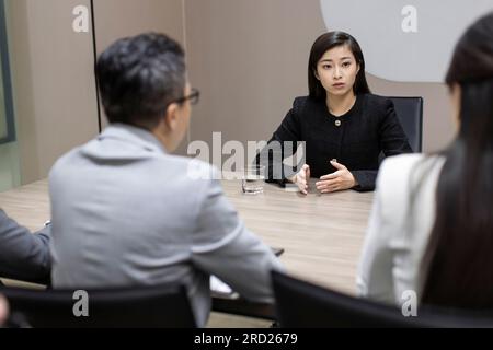 Confident Chinese businesswoman attending job interview Stock Photo - Alamy