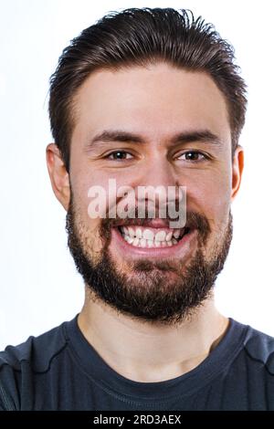 Portrait of a young bearded brunette man wearing hoodie standing ...