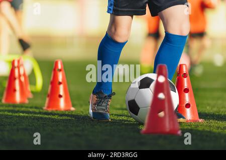 Soccer training drill for kids. Legs of football players attending ...