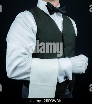 Portrait of Butler in Black Vest and White Gloves Holding Hands in ...
