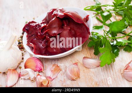 Image of raw rabbit liver with garlic and greens Stock Photo - Alamy