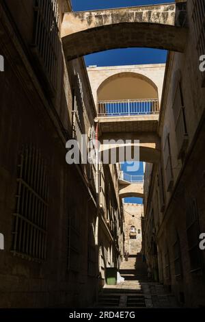 Narrow street view with a balcony under blue sky, vertical photo taken ...