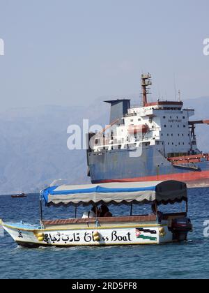 Aqaba, Jordan : Jordanian tourist glass boat at the weekend and a cargo ...