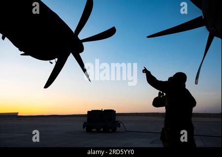 An Airman from the 73rd Special Operations Squadron marshals an AC-130J ...