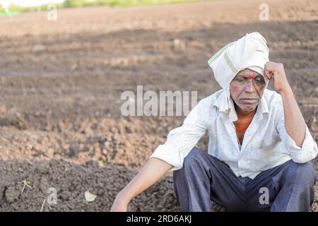 sad farmer, Elderly farmer man sitting in the soil & lost in thought ...