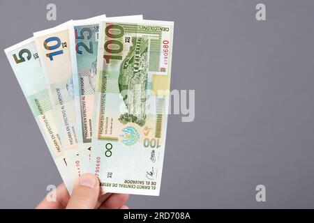 Salvadoran money - colon in the hand on a gray background Stock Photo ...