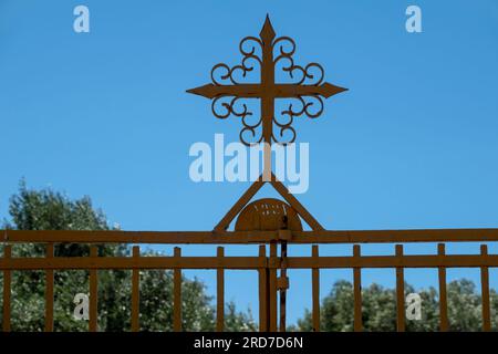 Wrought iron and painted steel church gate with decorative cross Stock ...