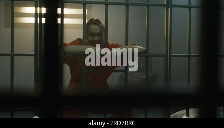 Insane female prisoner in orange uniform yells at neighbor inmate ...