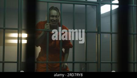 Insane female prisoner in orange uniform yells at neighbor inmate ...