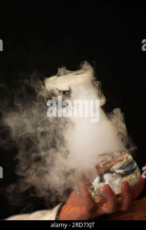 Glass flask with puffs of smoke as a result of liquid nitrogen reaction ...