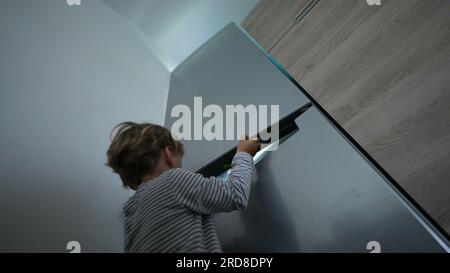 Child opens fridge door kid opening fridge Stock Photo - Alamy