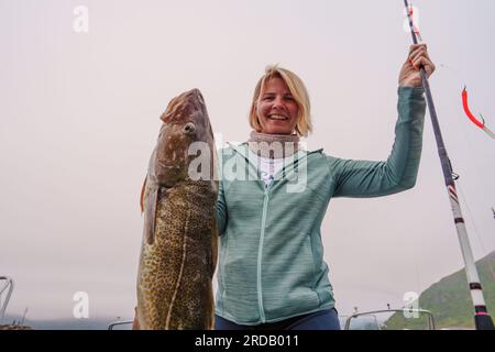 Happy Fisherwoman holding big arctic cod. Norway happy fishing. Woman ...