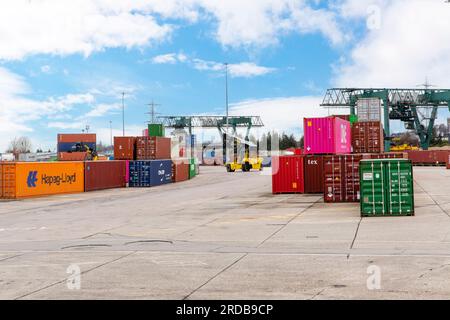 A top loader vehicle moves and stacks intermodal shipping containers at ...