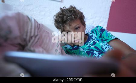 One addicted child staring at cellphone screen in the morning bed Stock ...