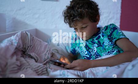 Child scrolling through phone screen in morning bed Stock Photo - Alamy