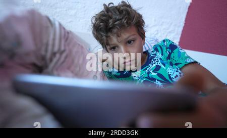 One addicted child staring at cellphone screen in the morning bed Stock ...