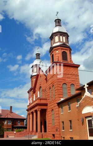 St Joseph’s red sandstone church tower topped with crucifix against ...