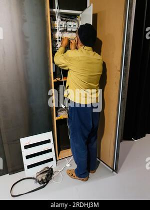 Electrical engineer checking electric cubicle and fixing connector ...