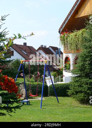 House with children's playground, ornamental garden, lawn with flowers ...