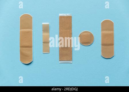 Different elastic medical plasters on blue background Stock Photo - Alamy