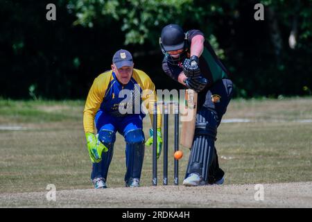 Clydach, Wales. 3 June 2023. A cricket bat rests against the stumps with the scoreboard in the ...