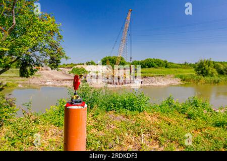 Part of leveler device on red metal pole ensures precise measurements ...