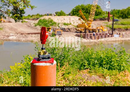 Part of leveler device on red metal pole ensures precise measurements ...