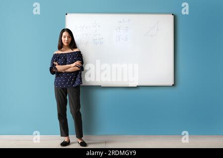 Asian Math teacher near flipboard in classroom Stock Photo - Alamy