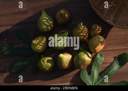 A few yellow figs on an brown wooden background in sunshine Stock Photo ...