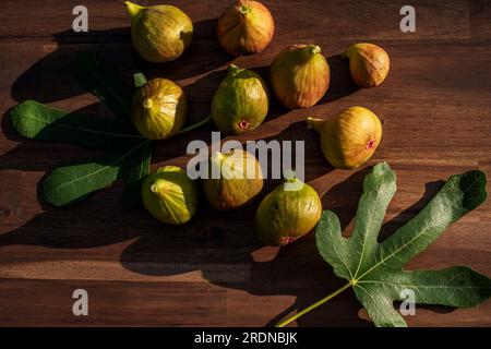 A few yellow figs on an brown wooden background in sunshine Stock Photo ...