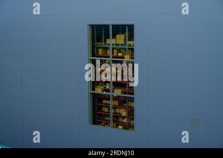 Boxes and pallets visible through a window at a large warehouse Stock ...