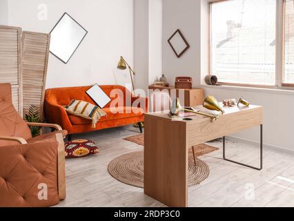Modern workplace and sofa in messy office Stock Photo - Alamy