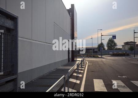 Road next to a building with a roundabout afar on a cloudy sunset Stock ...