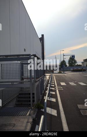 Road next to a building with a roundabout afar on a cloudy sunset Stock ...
