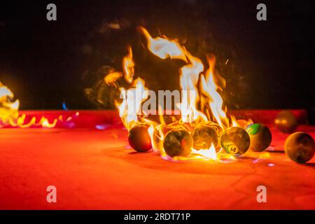 Billiard balls are photographed on fire while sitting outdoors in an ...