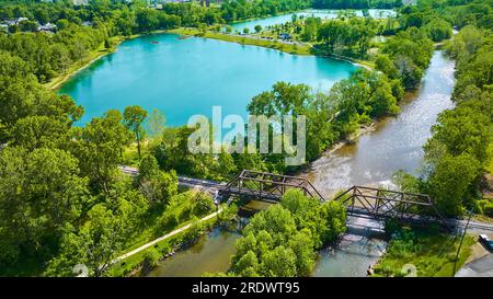 Aerial of Ariel Foundation Park with train bridge and gorgeous teal ...