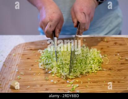 Hands of man chopping Chinese cabbage, preparing for fillings to make ...