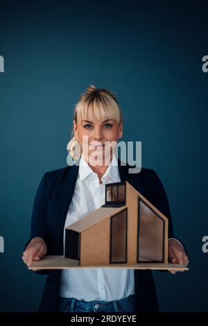 Smiling businesswoman holding model Stock Photo - Alamy